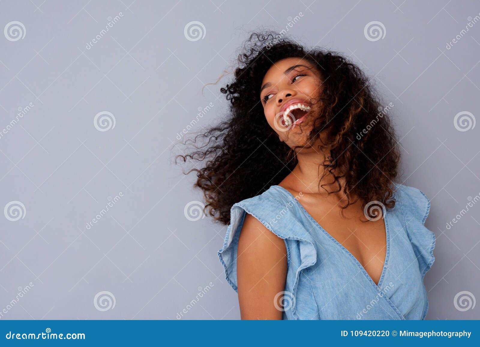 Close Up Beautiful Young Black Woman Laughing Against Gray Wall Stock