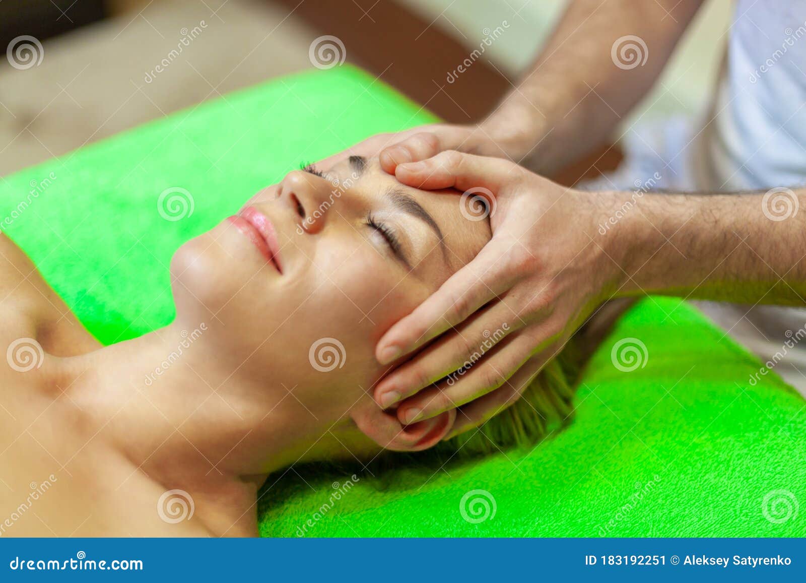 Close Up Of Beautiful Young Woman Relaxing With Face Massage At Beauty