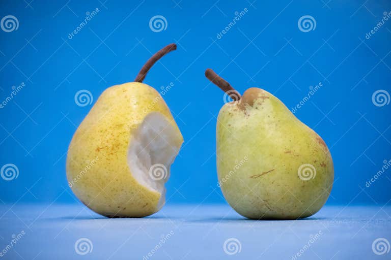 Close Up of a Bitten Pear is Standing and the Background is Blue Stock ...