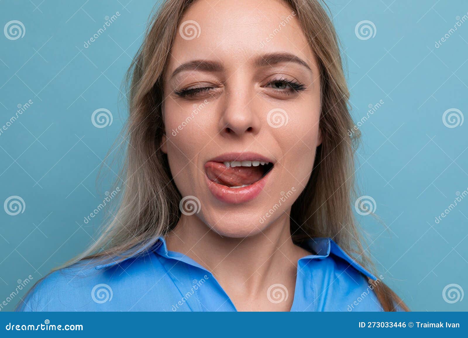 Close-up of Blond Young Woman Winking on Blue Background Stock Photo ...