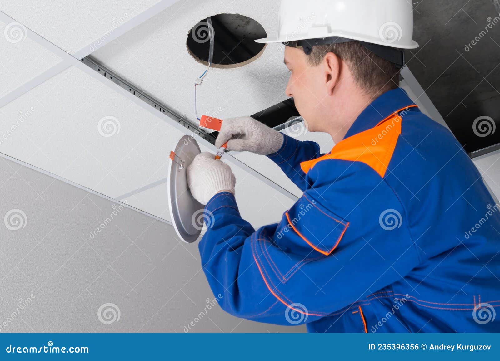 Close-up, Blue-uniformed Foreman Troubleshooting False Ceiling Lighting ...