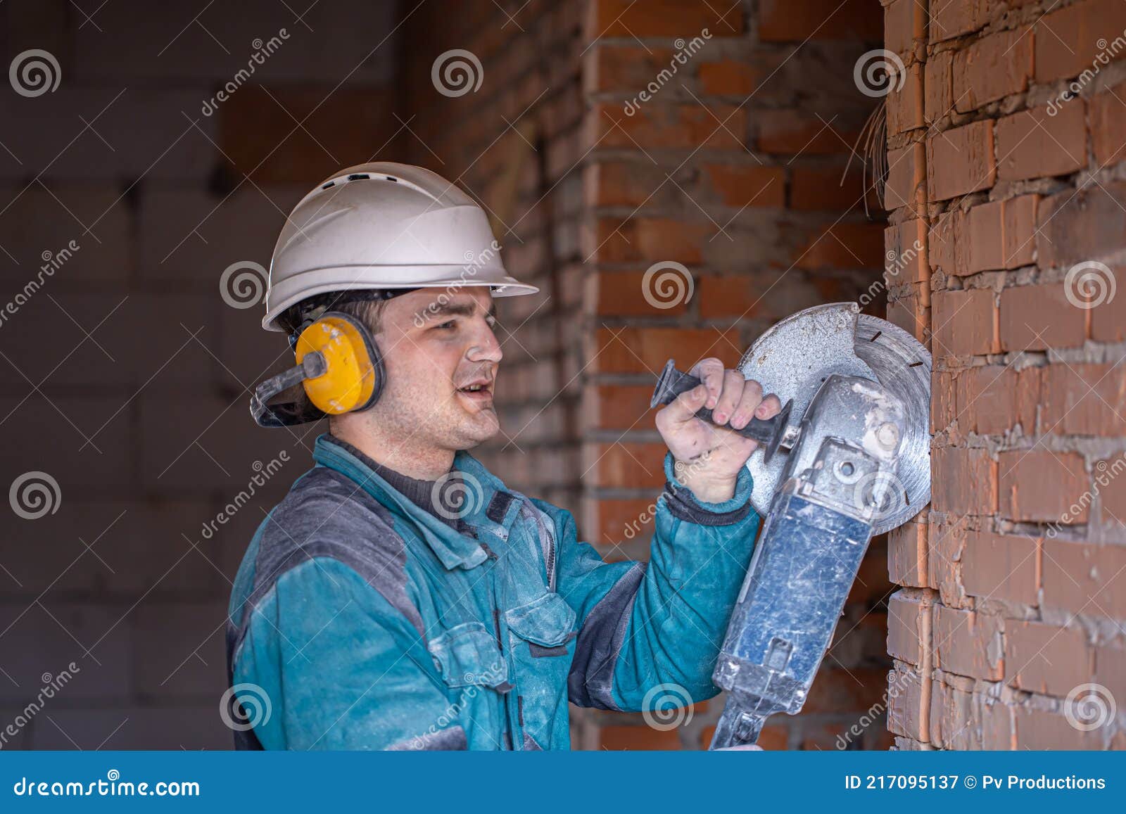 Handyman at a Construction Site in the Process of Cutting with a ...