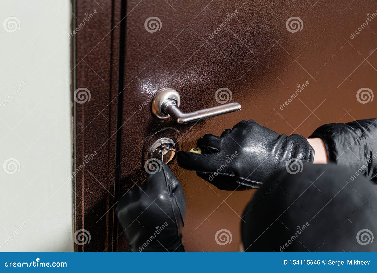 Close Up of a Burglar with Gloves Picking a Lock. Thief with a Passkey ...