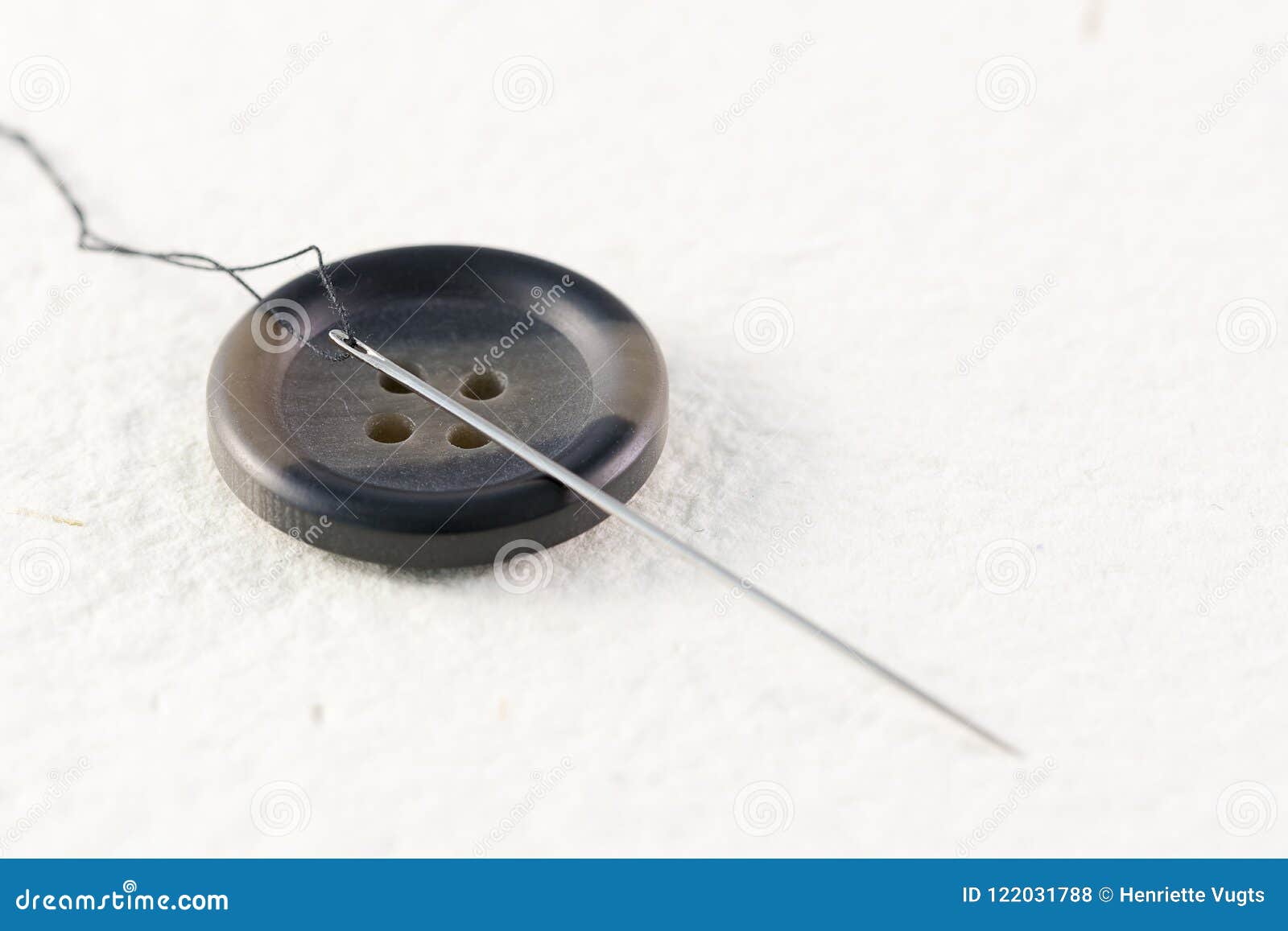 Close Up of a Button with Needle and Thread on a White Background Stock ...