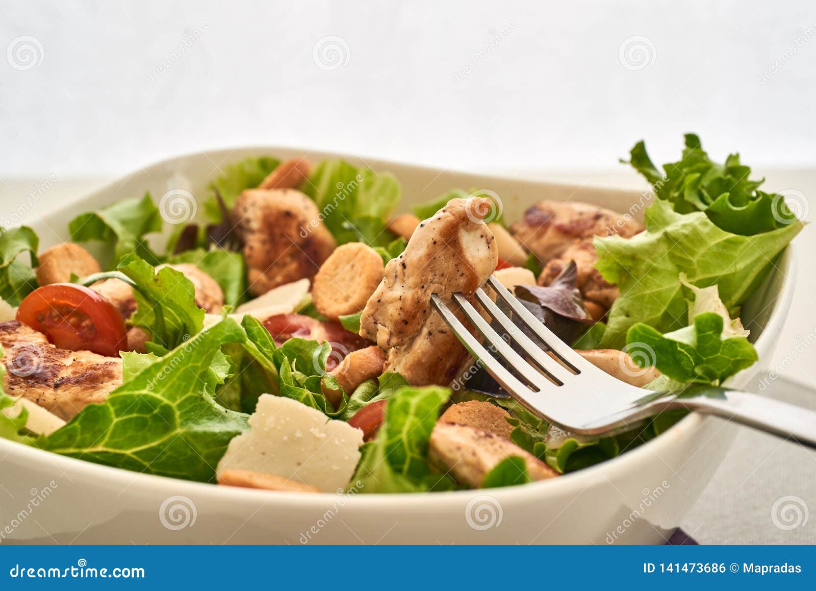 Close Up on a Cesar Salad and a Chunk of Chicken in a Fork Stock Photo ...