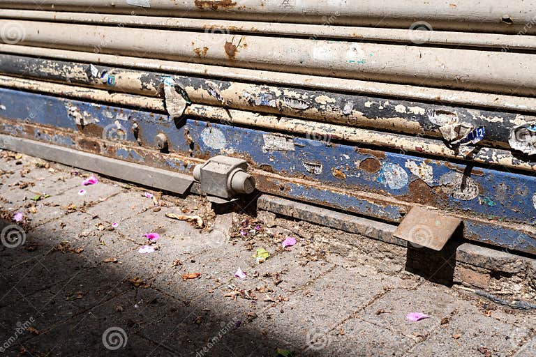 Close-up of a Closed Metal Shutter with Signs of Wear and Chipped Paint ...