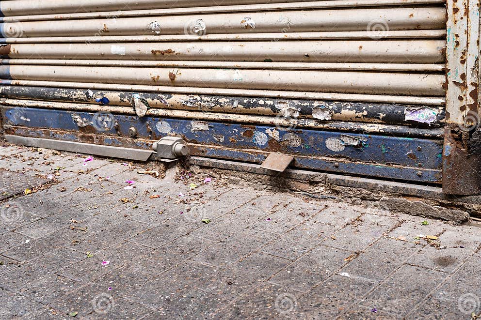 Close-up of a Closed Metal Shutter with Signs of Wear and Chipped Paint ...
