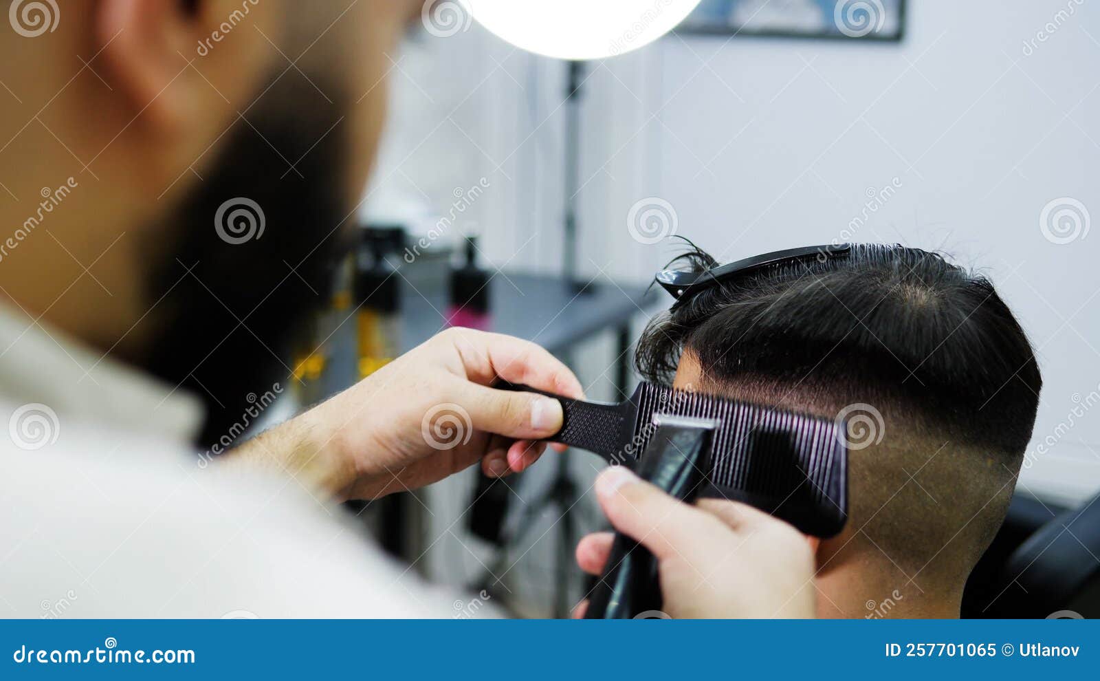A Close-up of a Comb and a Trimmer in the Hands of Barbara Skillfully ...