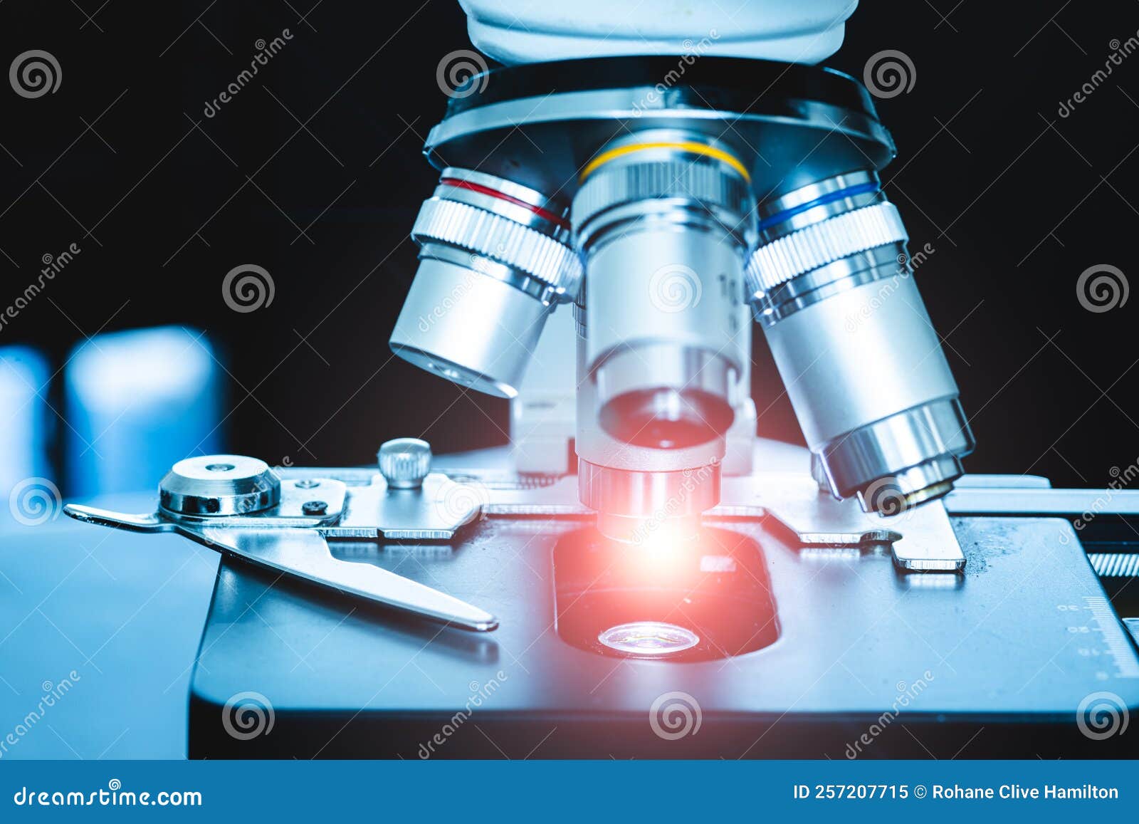 Close Up of Compound Microscope with Ray of Orange Light Shining in Lab ...