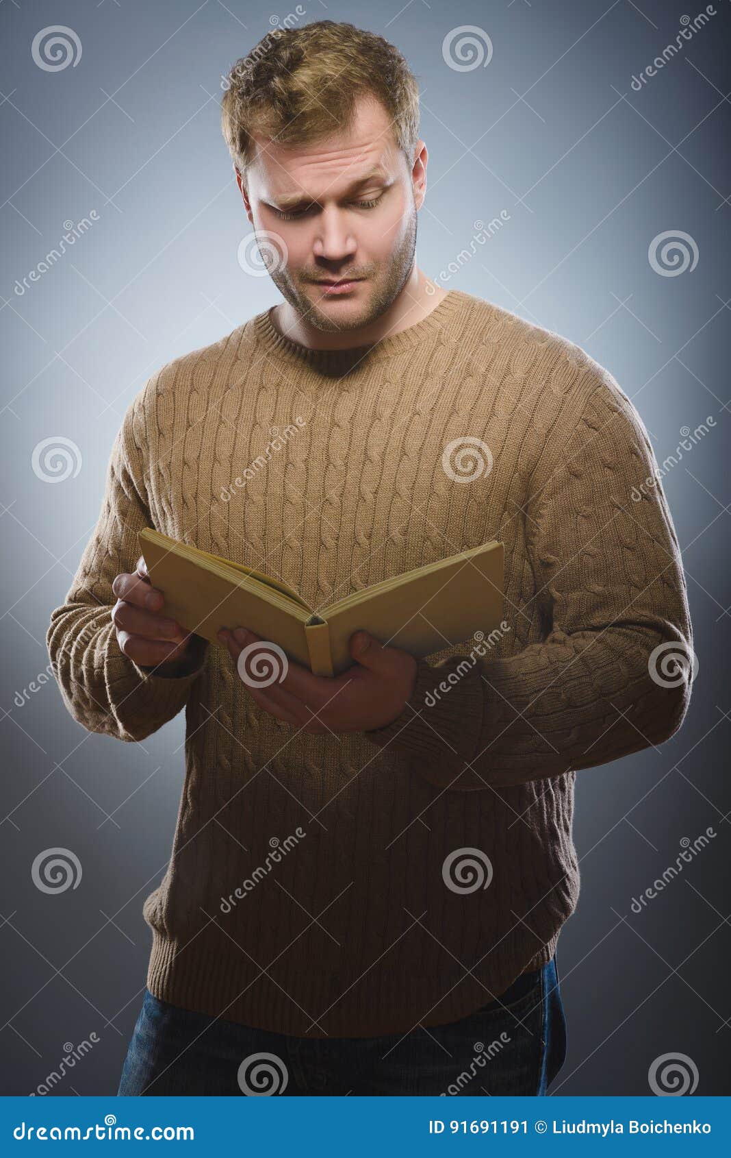 Close-up Of Confused Man Reading Book Against Gray Background Stock ...