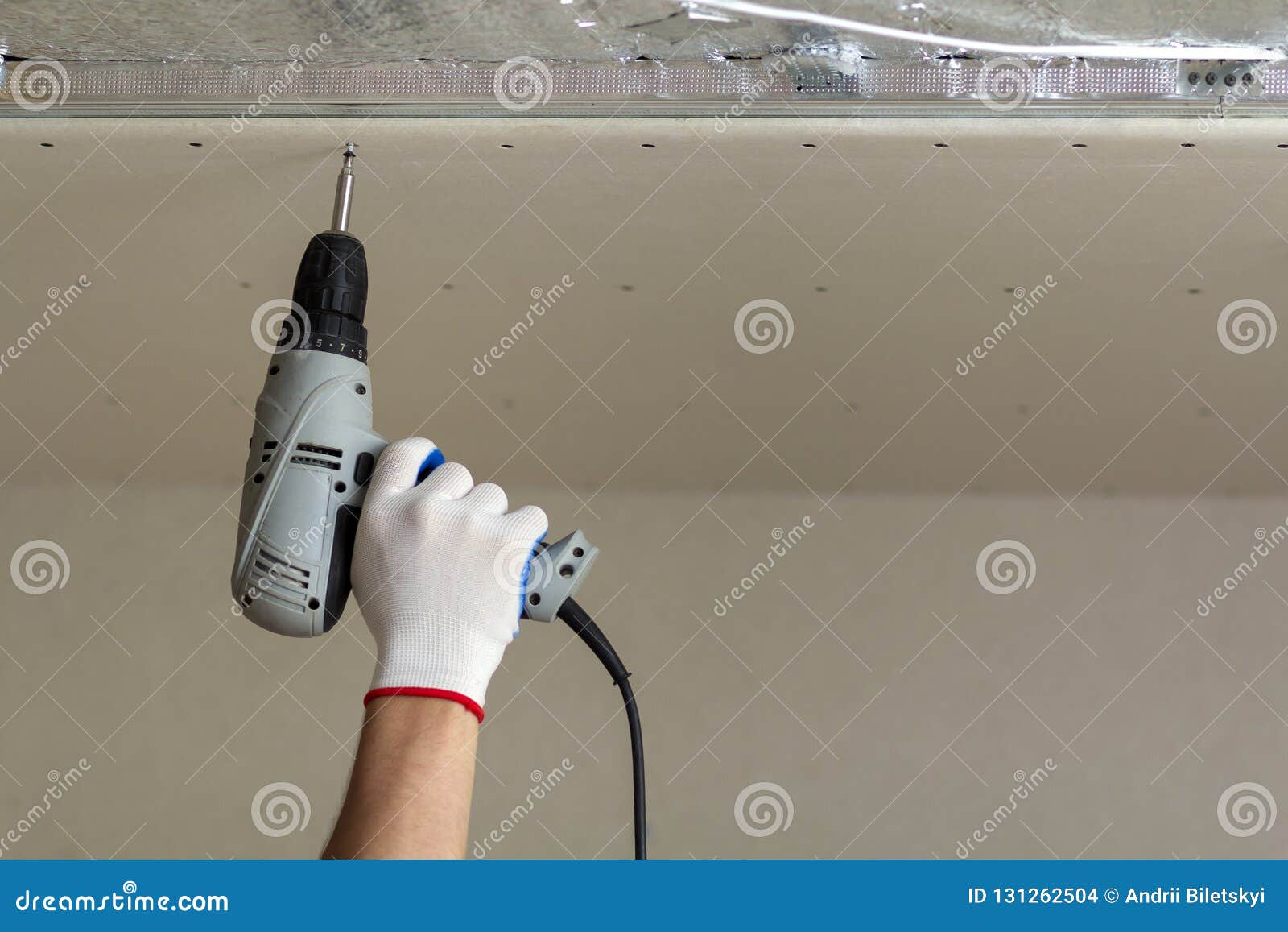 Close-up of Constructor Worker Hand in Protective Glove with Electrical Cordless Screwdriver ...