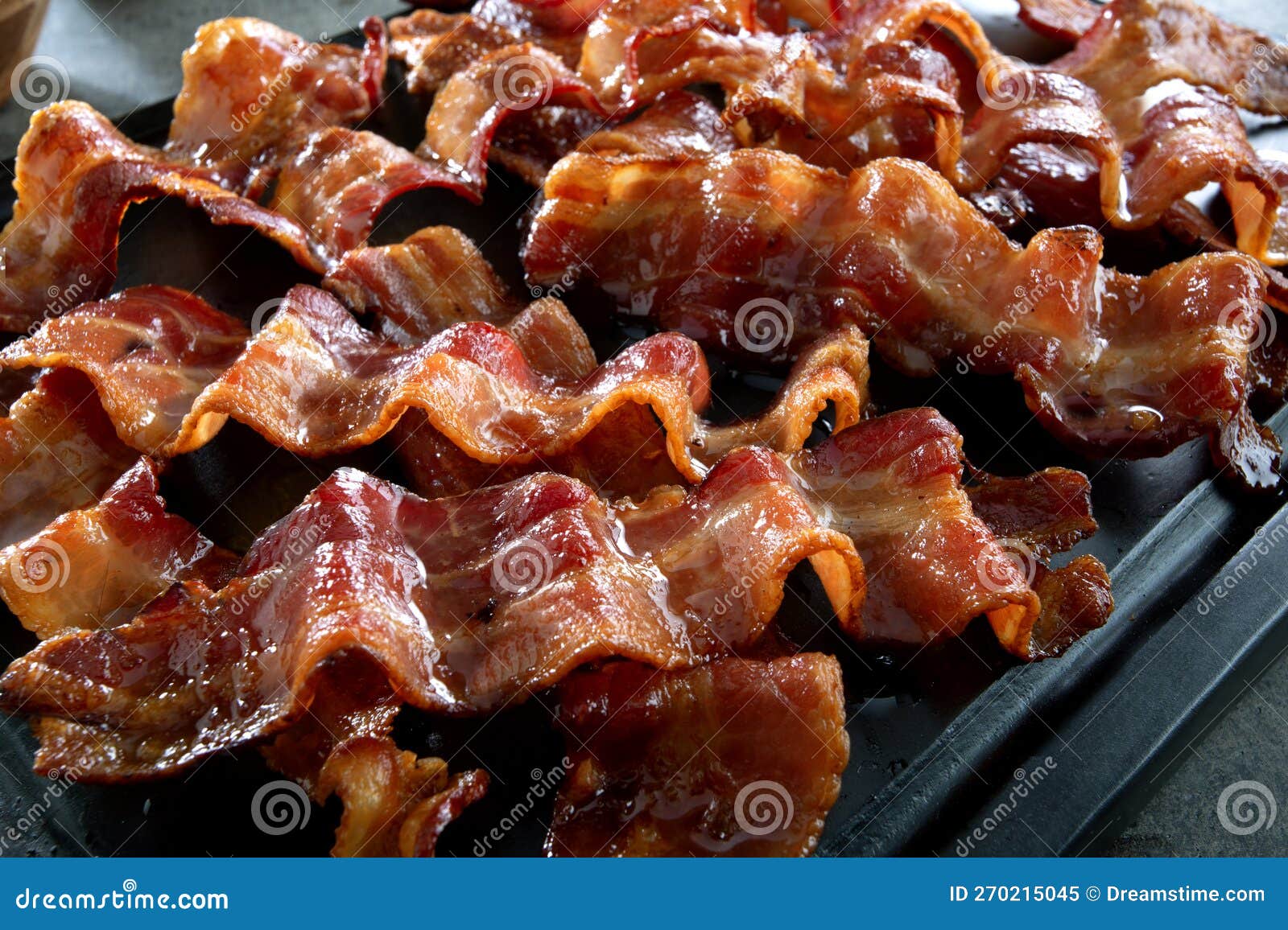 Close-up of Crispy Strips of Bacon Overlapping on a Black Plate Stock ...