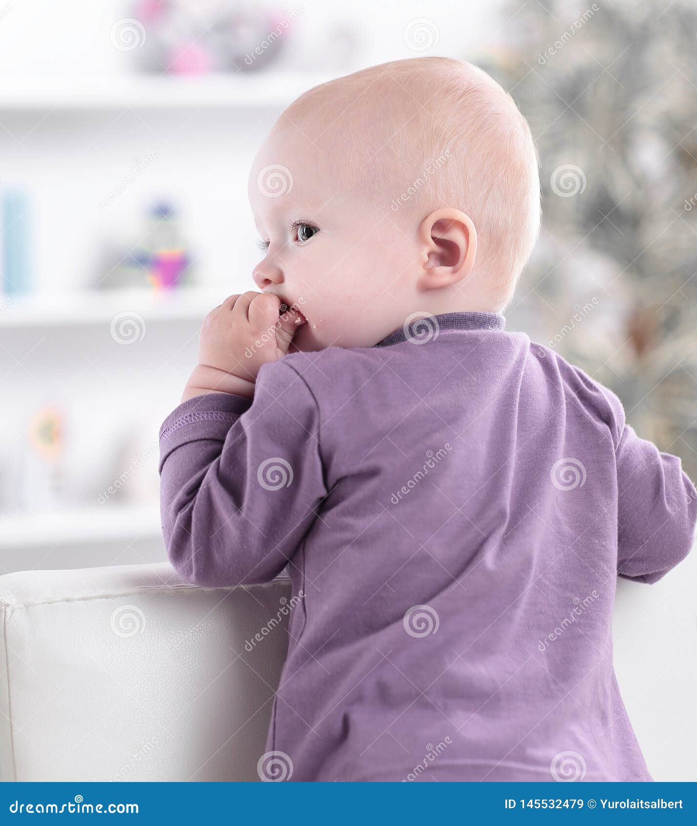 Close Up.cute Baby Eating a Cookie while Sitting on the Couch Stock ...