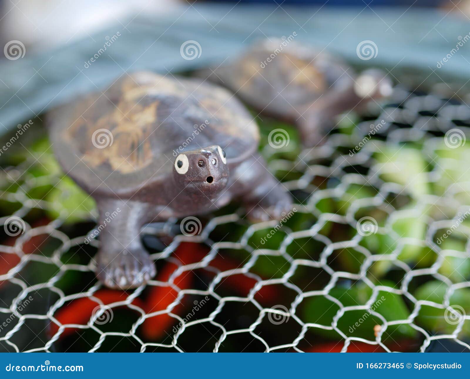 Close-up of Cute Ceramic Garden Decor Turtles on Hexagonal Mesh Grids ...