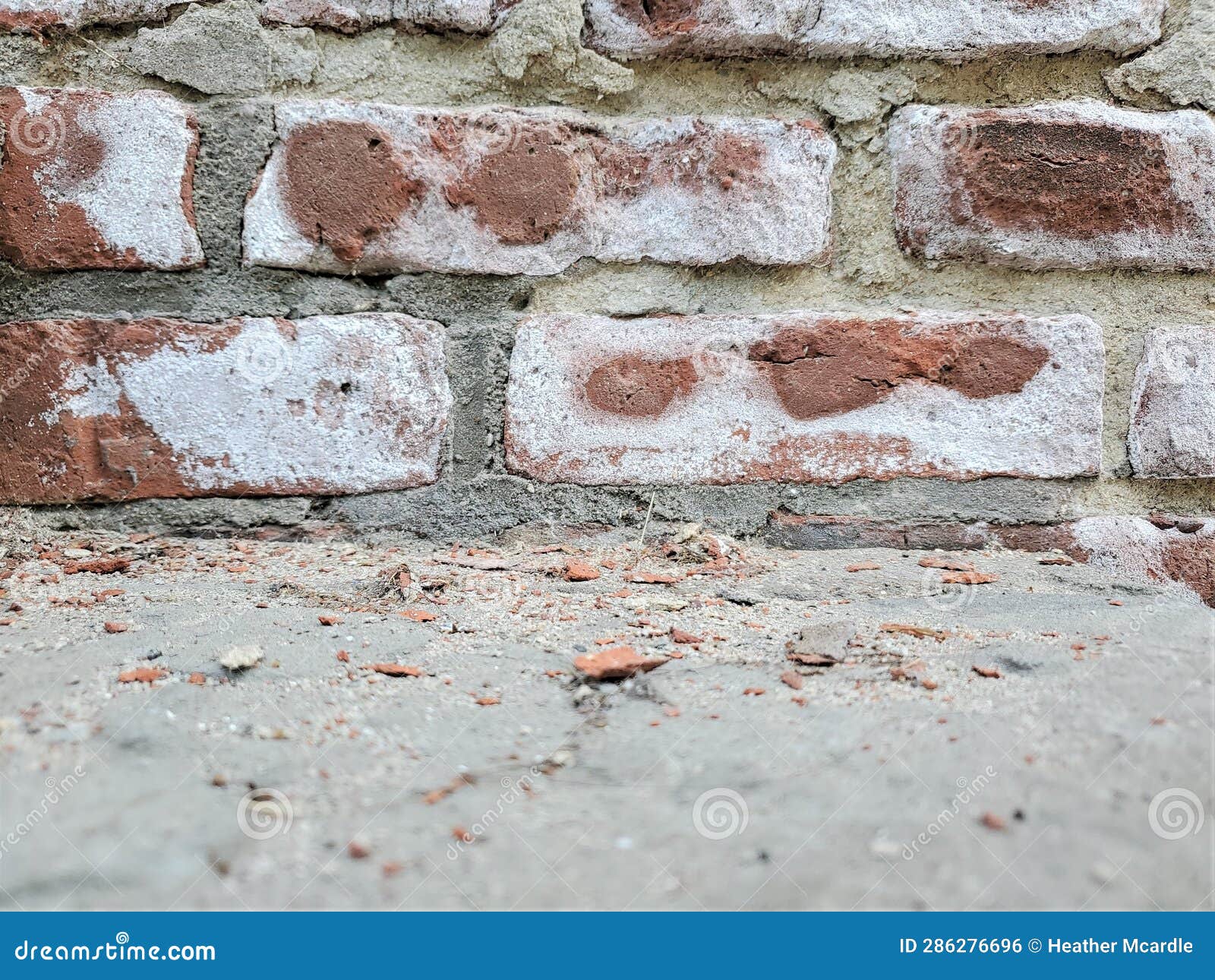 Close Up of Damage To Crumbling Red Brick and Mortar Wall Over Stone ...