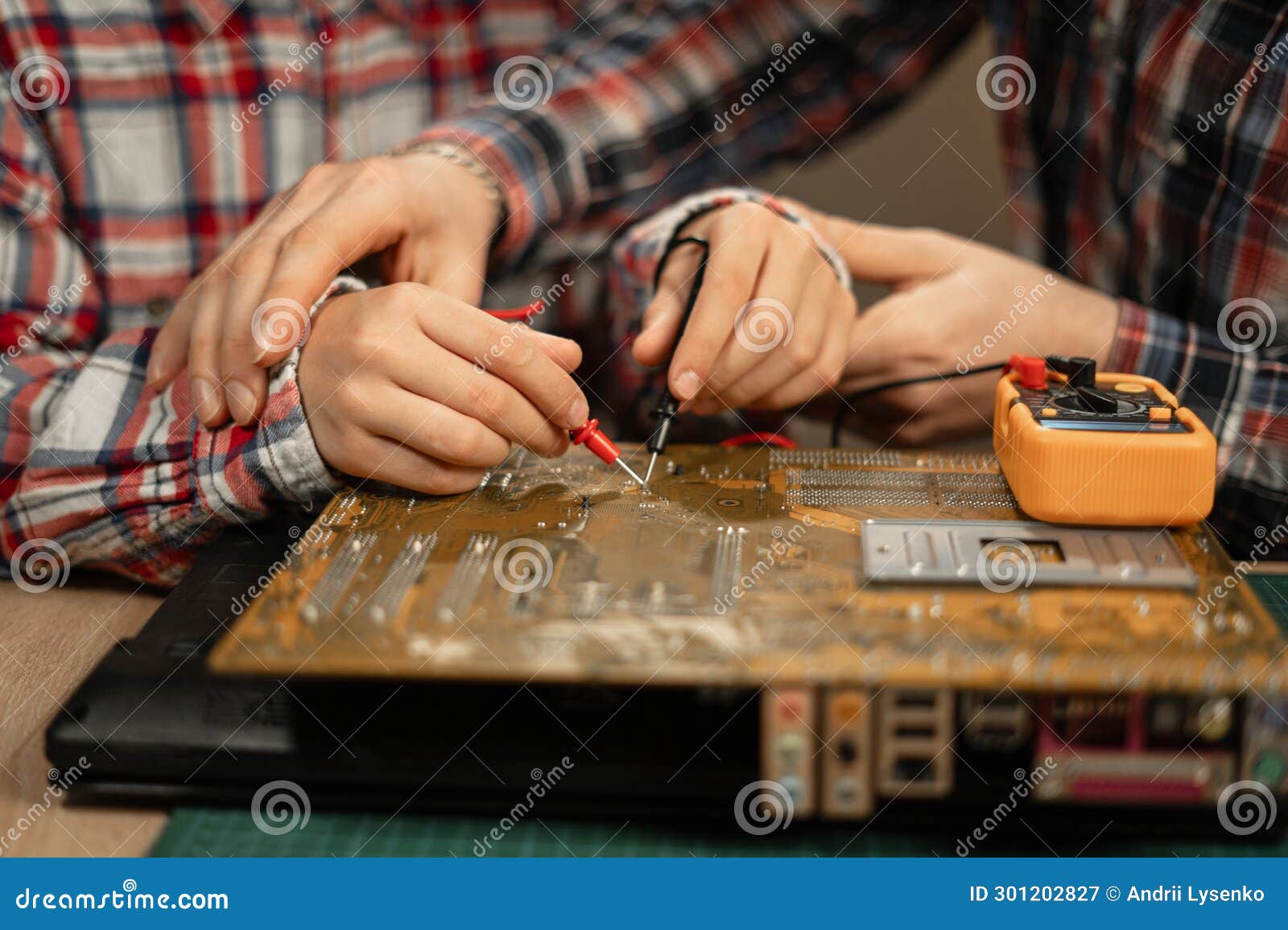 Close-up of Father and Son Hands Testing Laptop Motherboard Using ...
