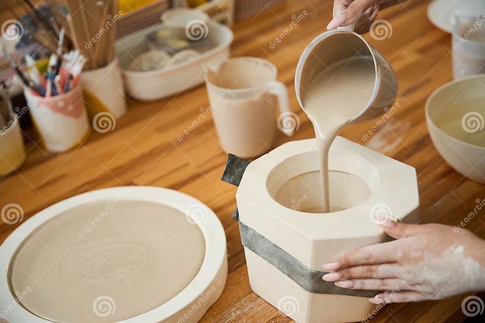 Close Up of Female Hands Pouring Pottery Mixture into Mold for Mug ...