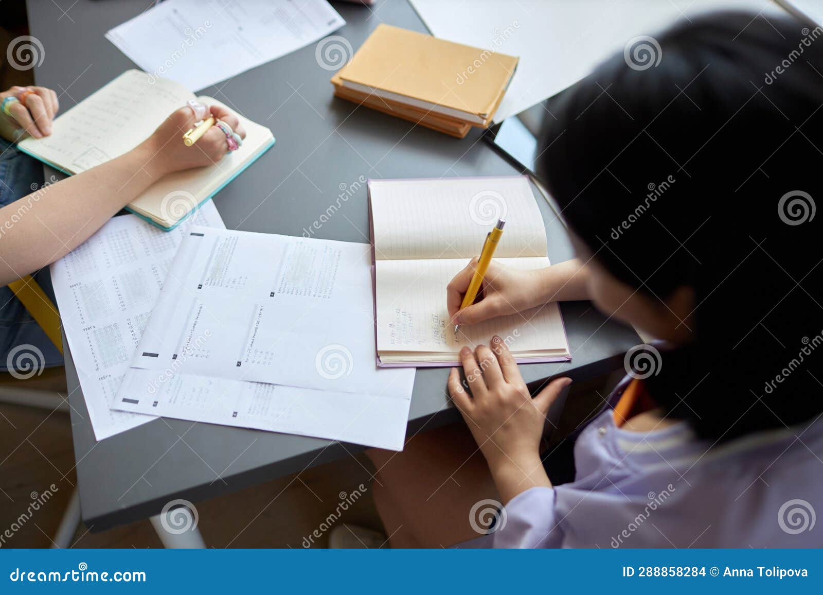 Close-up of Female Student Making Notes on Page of Copybook during Test ...