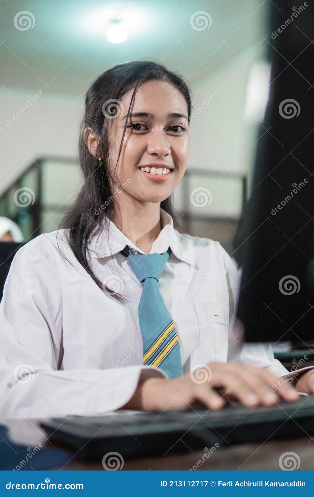 Close Up of a Female Student Smiling at the Camera while Typing the ...
