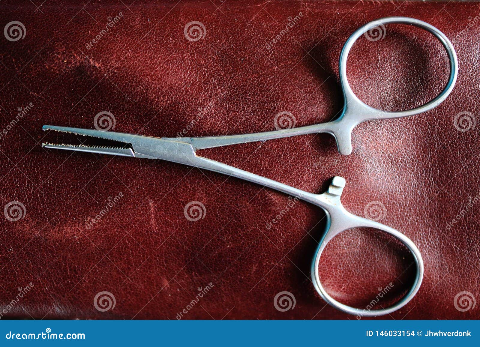 Close Up of a Forceps on a Background of Red Leather Stock Photo ...