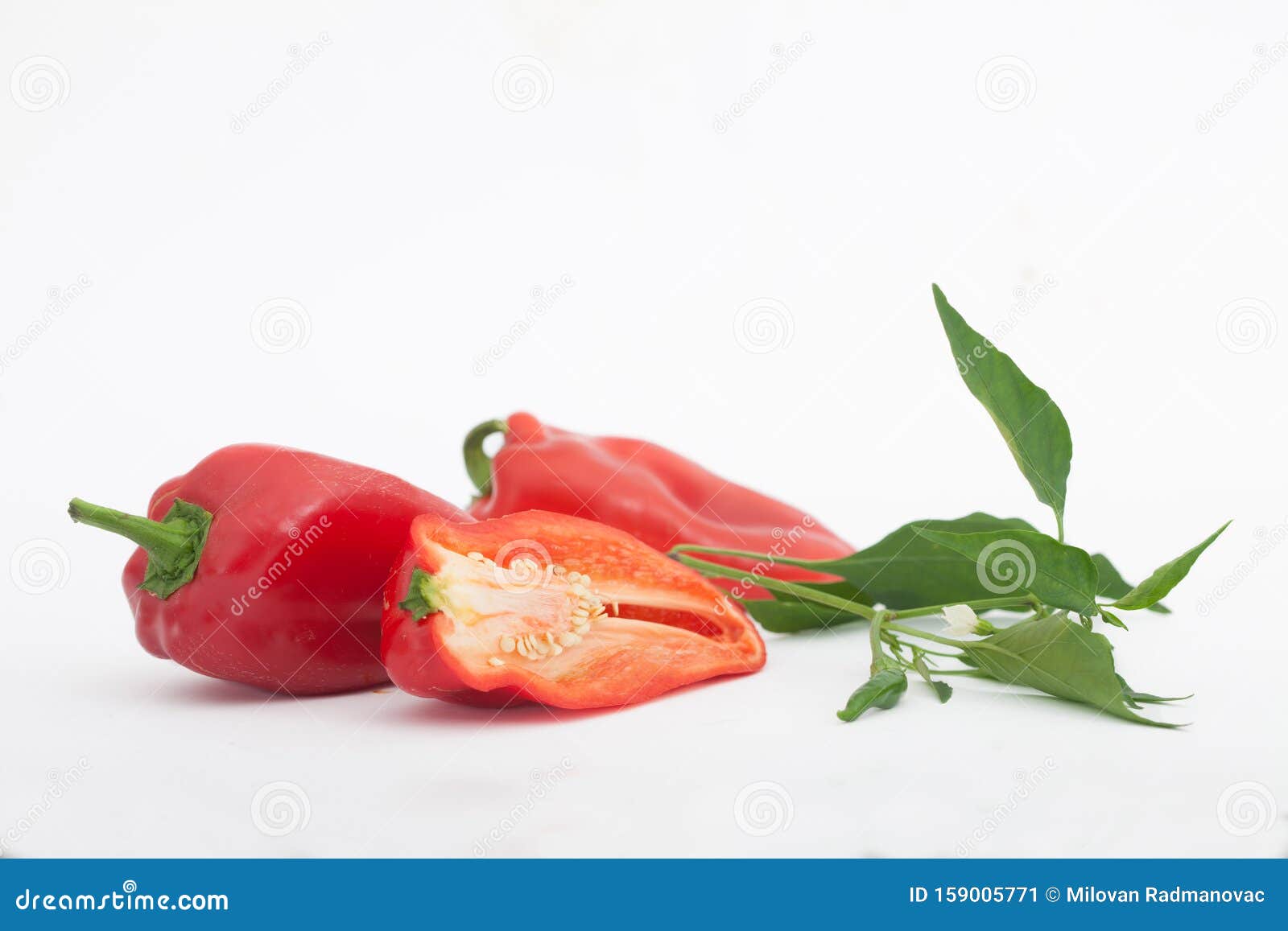 Close-up of Fresh Red Peppers, Two Whole and One Paprika Slice on White ... Close-up of Fresh Red Peppers, Two Whole and One Paprika Slice on White ...