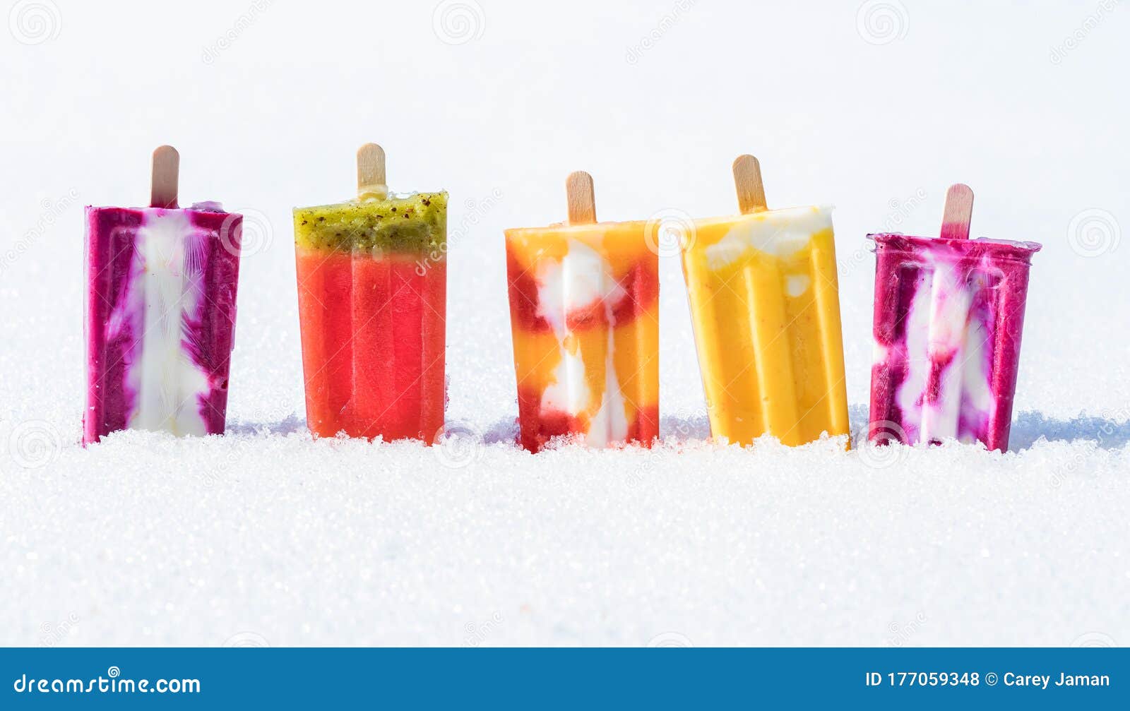 A Close Up Front View of a Row of Upside Down Popsicles in Snow Against ...