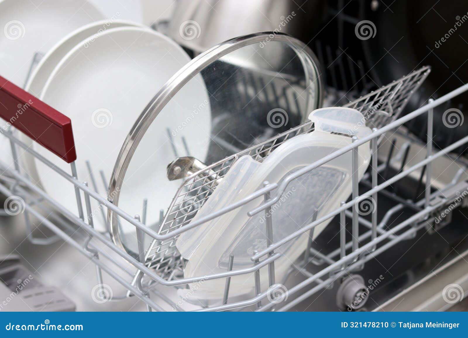 Close Up of a Full Dishwasher with Clean Plates, Lids, Glassware in the ...