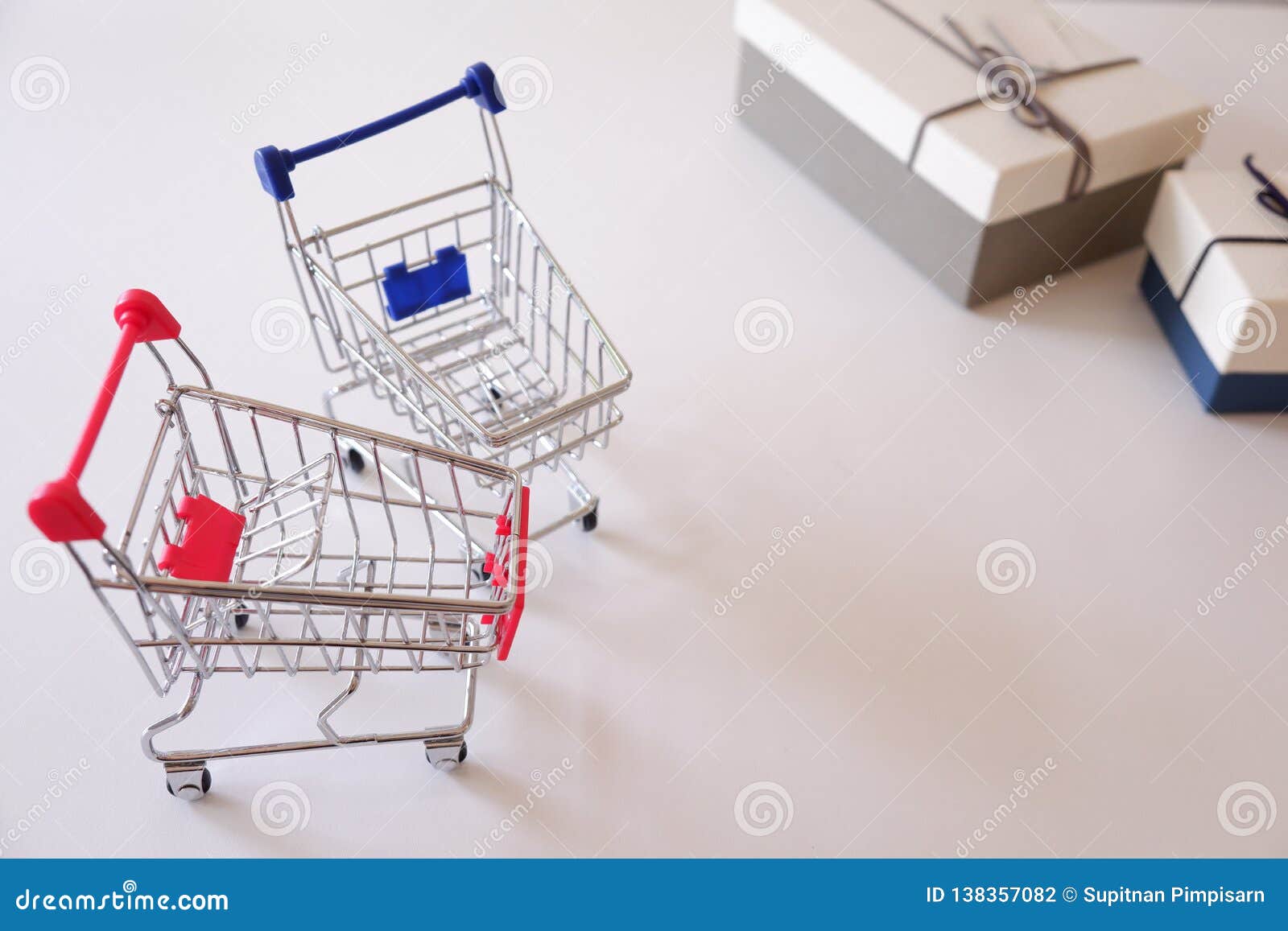 Close-up of Gift Boxes and Shopping Carts on White Desk Stock Photo ...