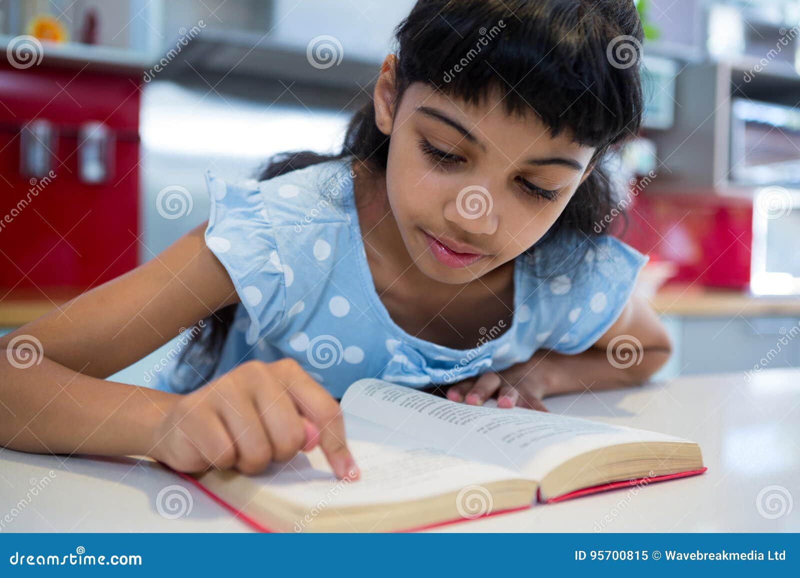 Close-up of Girl Pointing while Reading Novel in Kitchen Stock Image ...