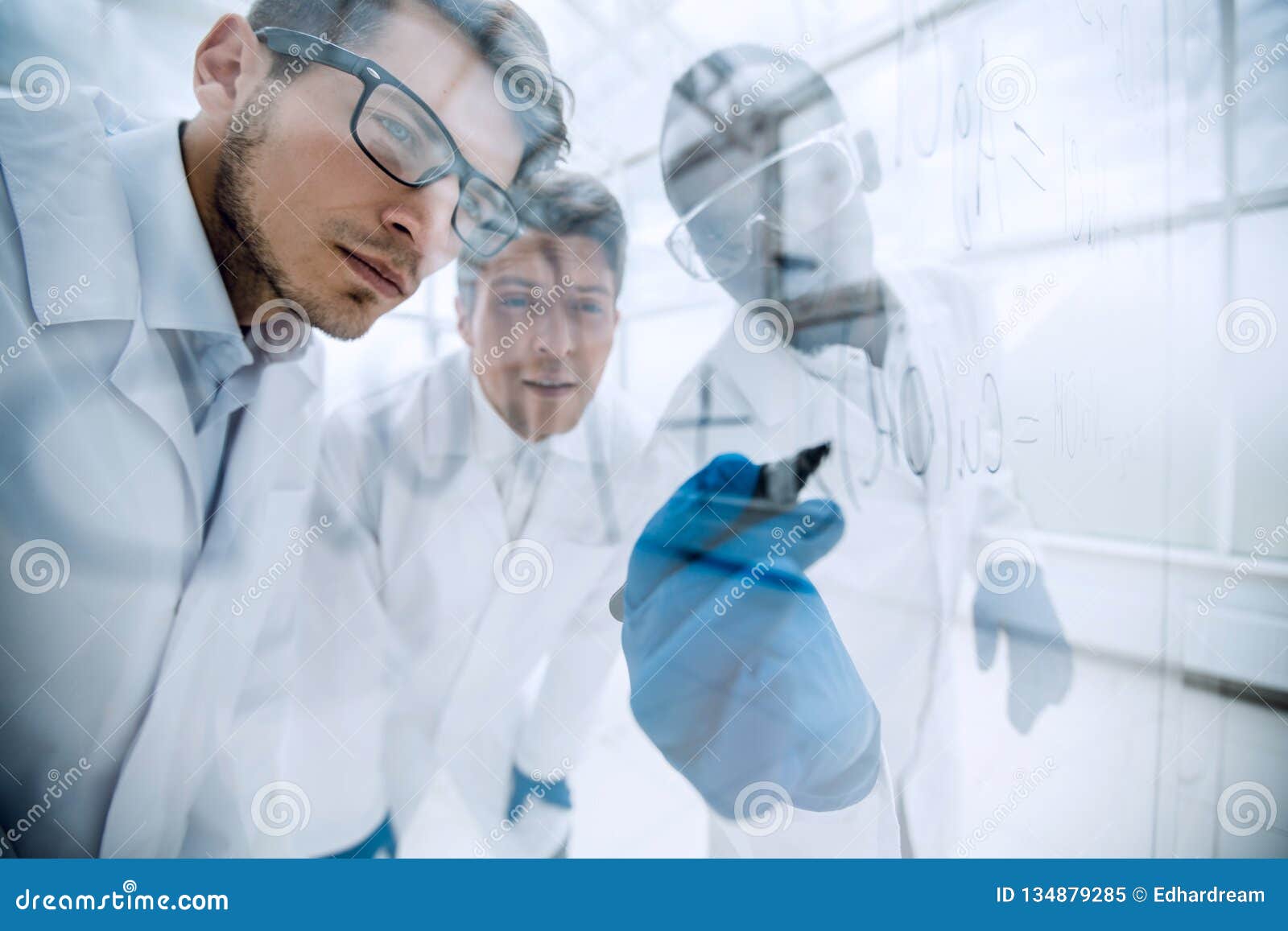 Close Up.a Group of Scientists Recording the Formula on a Glass Board ... Close Up.a Group of Scientists Recording the Formula on a Glass Board ...