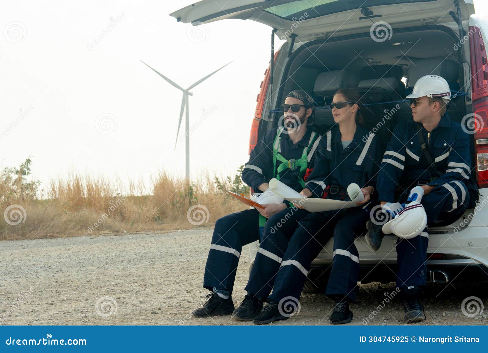 Close Up Group of Technician Workers Sit on Back of Van and Discuss ...
