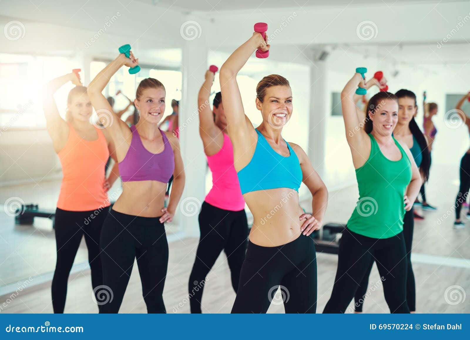 Close-up of Group of Young Women Doing Exercise with Dumbbells on ...
