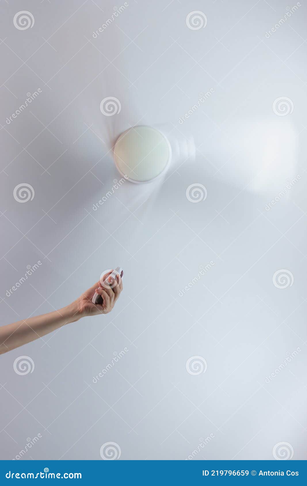 Close-up of Hand Holding Remote Control of White Ceiling Fan. Hand ...