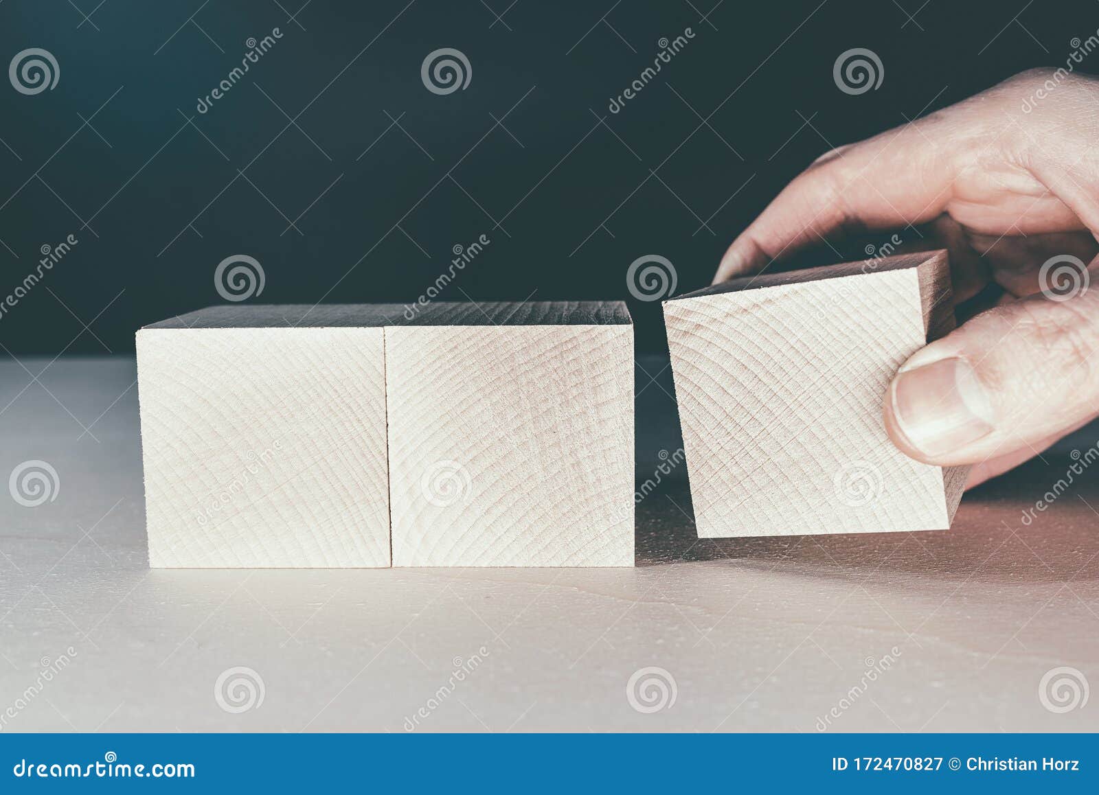 Close-up of Hand Placing Three Wooden Blocks on Table Stock Image ...