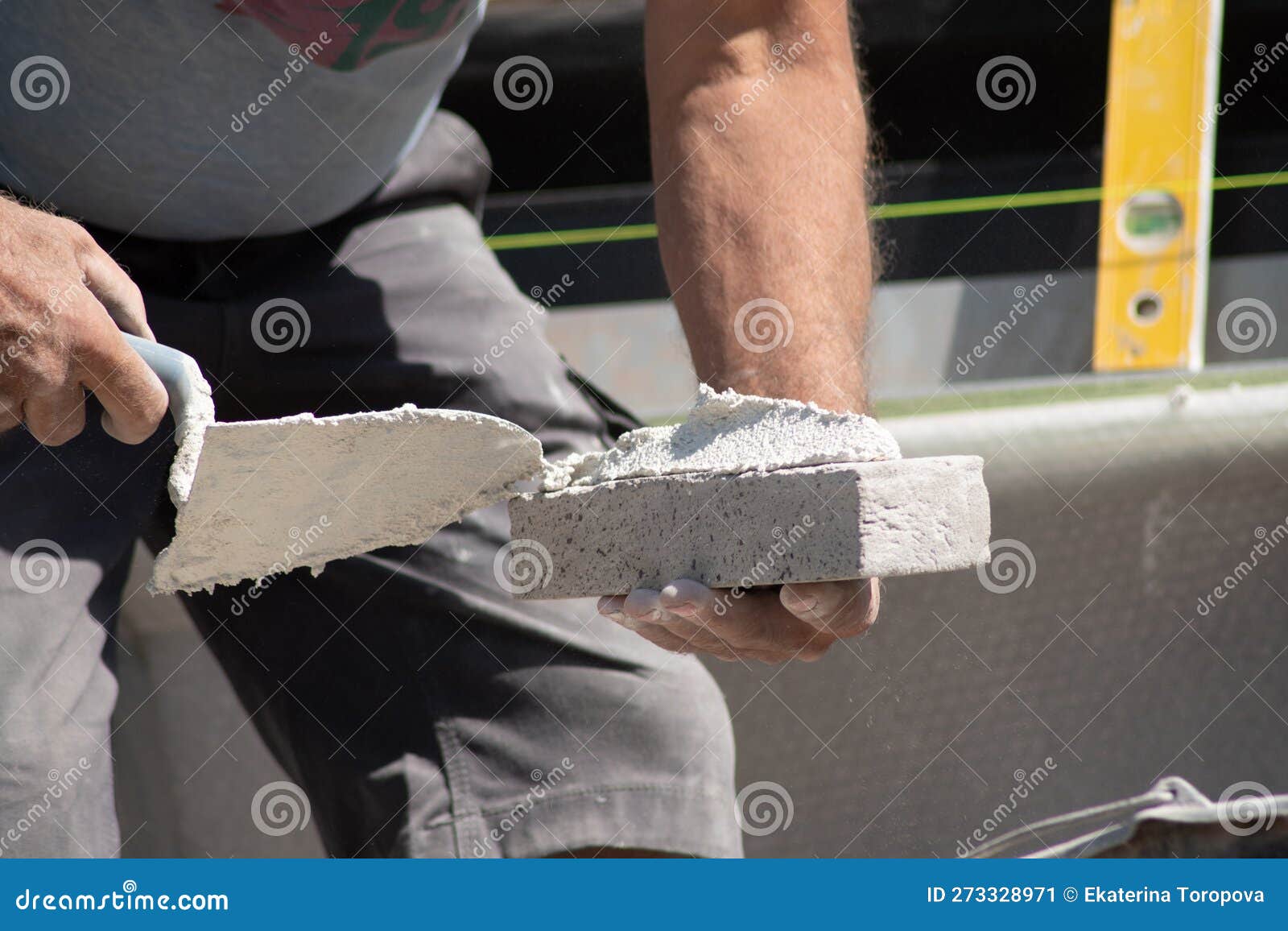 Close Up of the Hands of a Bricklayer Applying Cement Mortar To a Brick ...