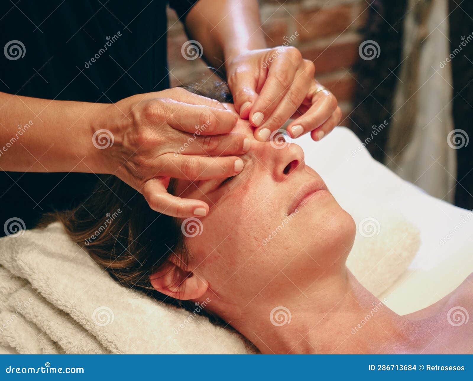 Close Up Masseuse Doing Face Pressure Relaxing Massage To Young