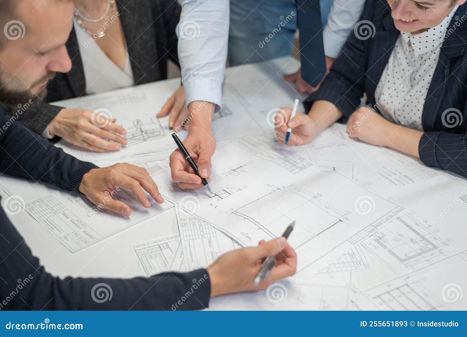 Close-up of the Hands of Four Colleagues with Blueprints on the Table ...