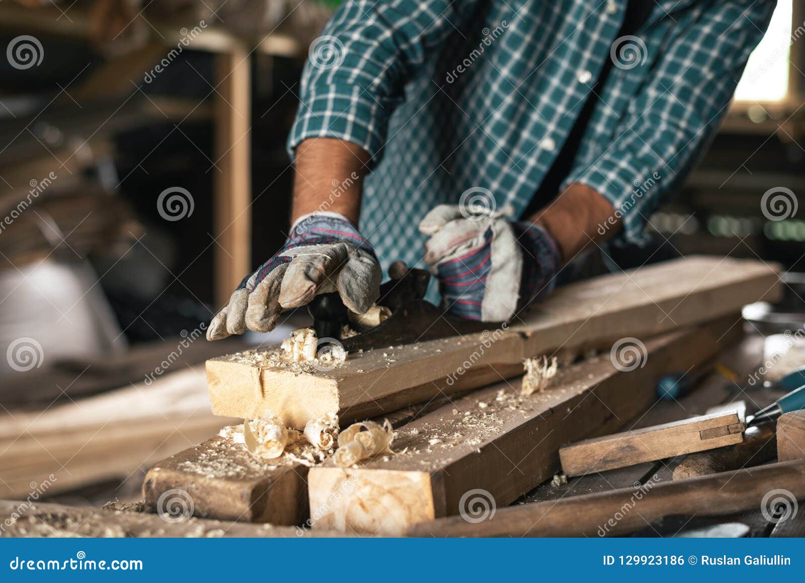 Close-up of the Hands of a Gloved Carpenter with a Hand Planer Handles ...