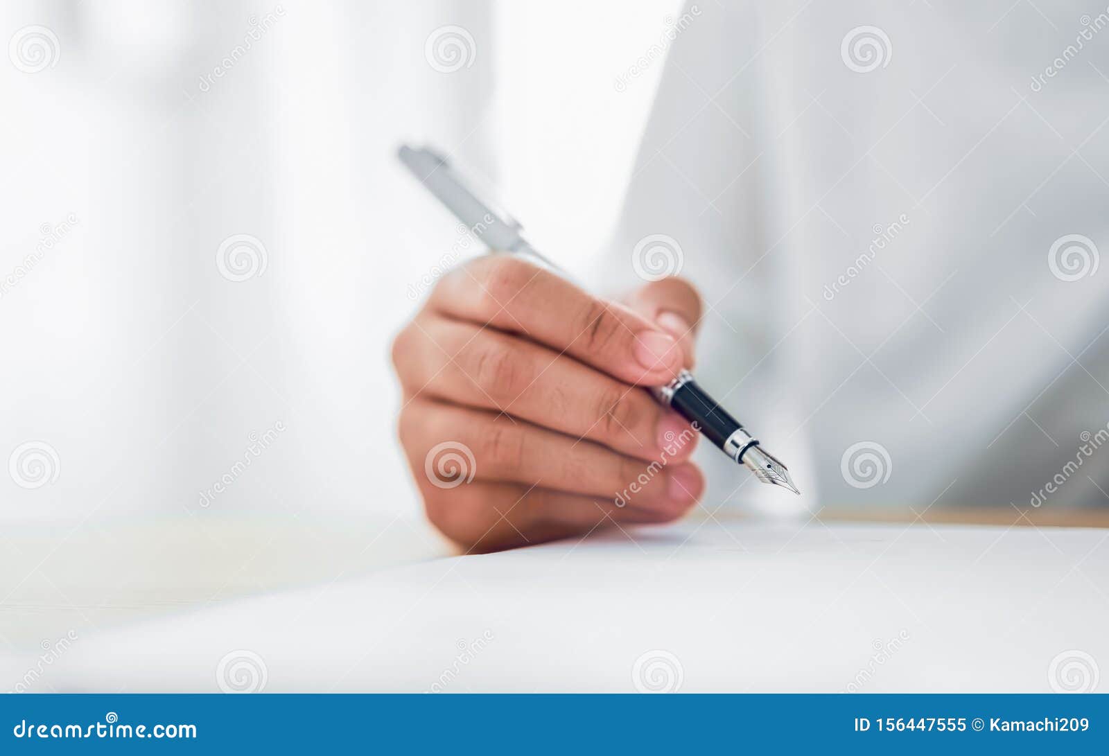 Close-up of Hands Holding Pen and Writing on Notepad, Paper on Desk ...