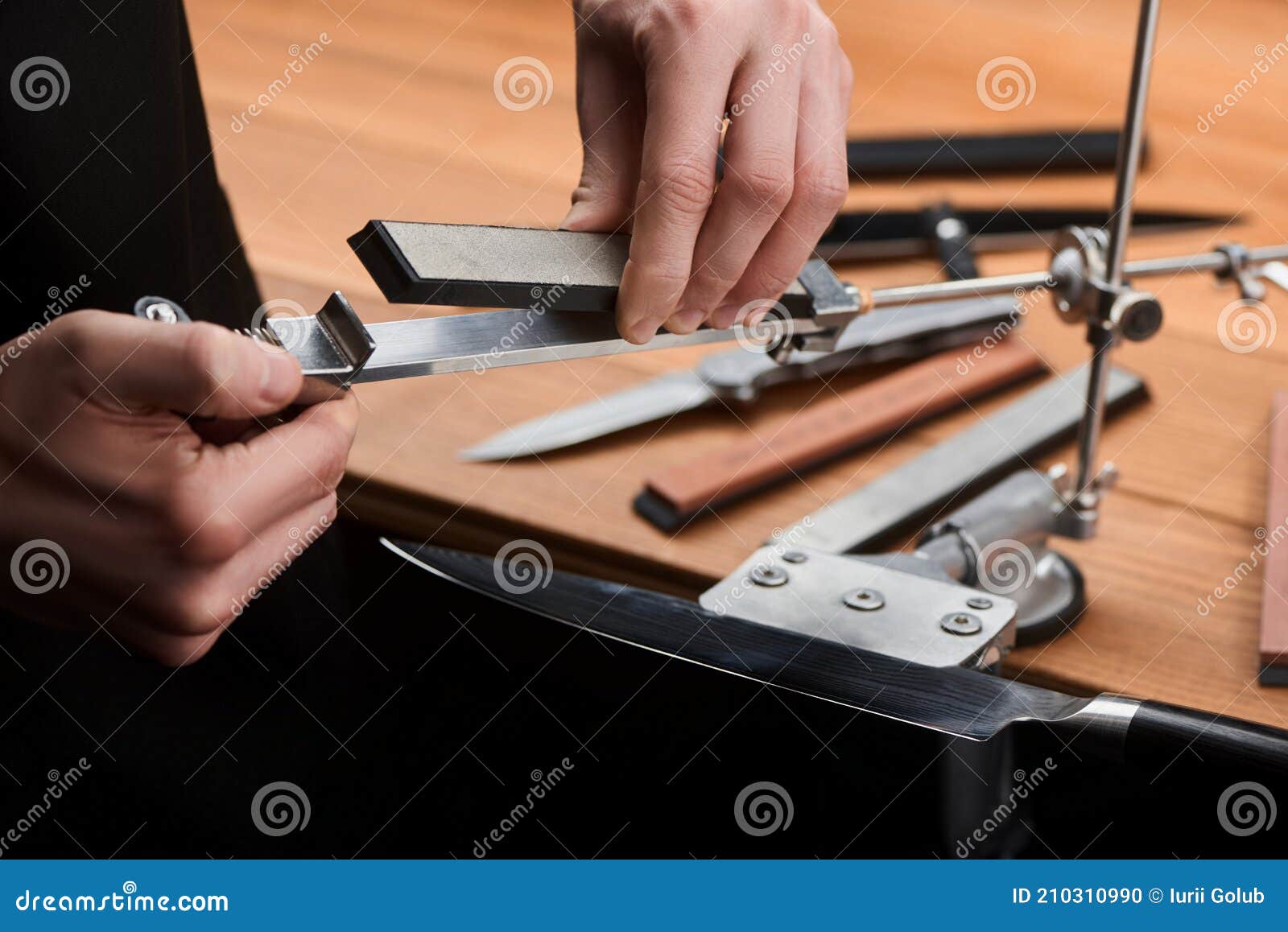 Close-up on Hands Inserting a Whetstone into a Manual Sharpener Machine ...