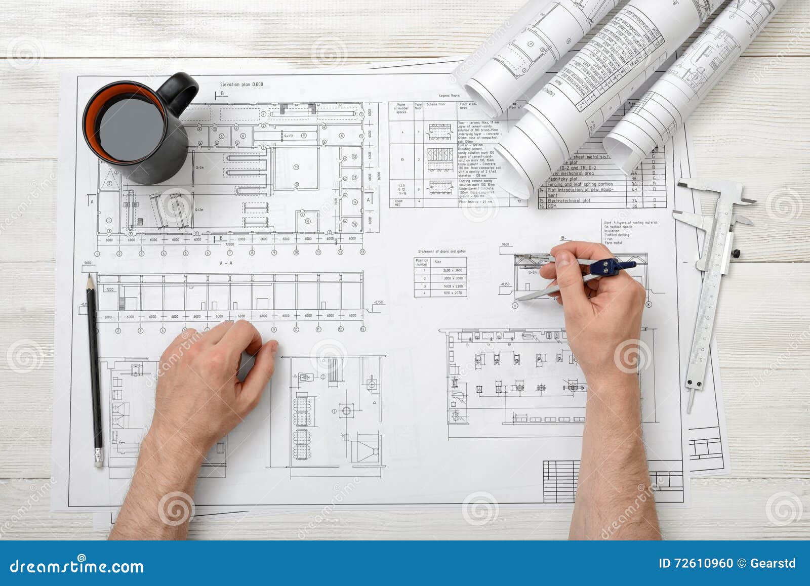 Close-up Hands of Man Holding an Engineering Divider Over Drawing Plan ...