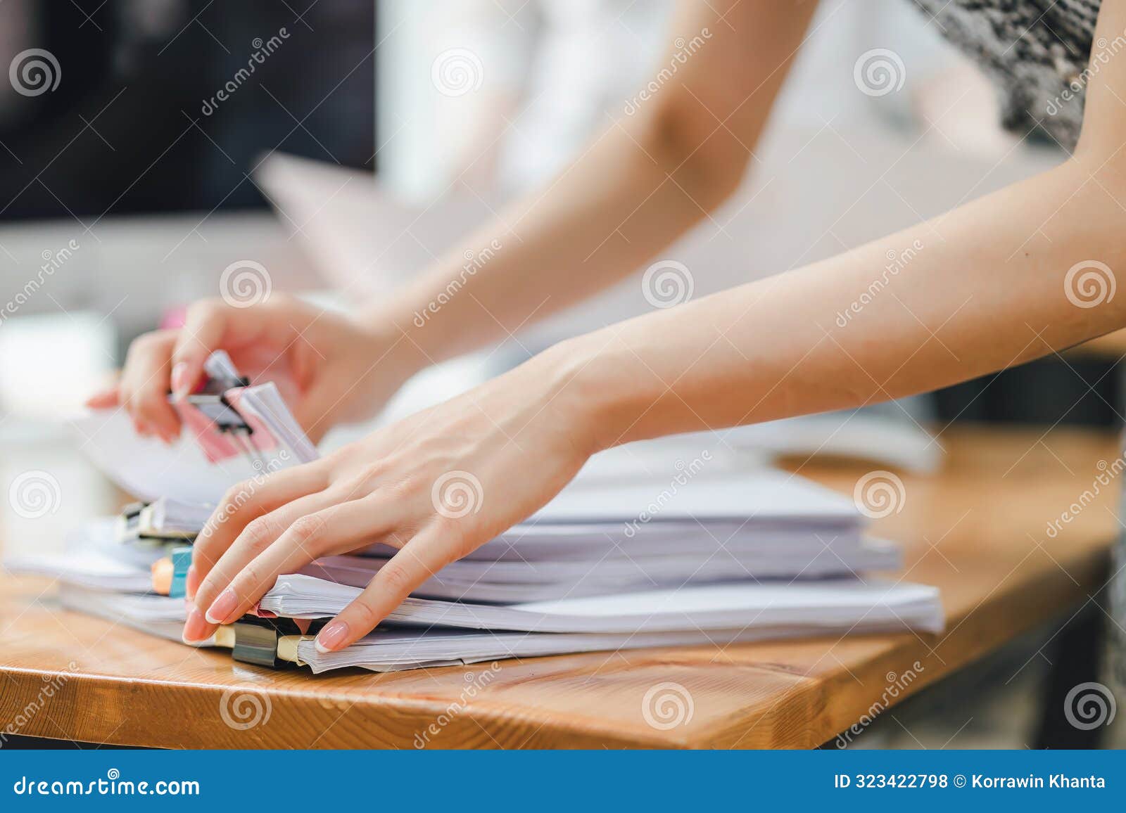 Close-up of Hands Organizing a Stack of Documents with Colorful Binder ...