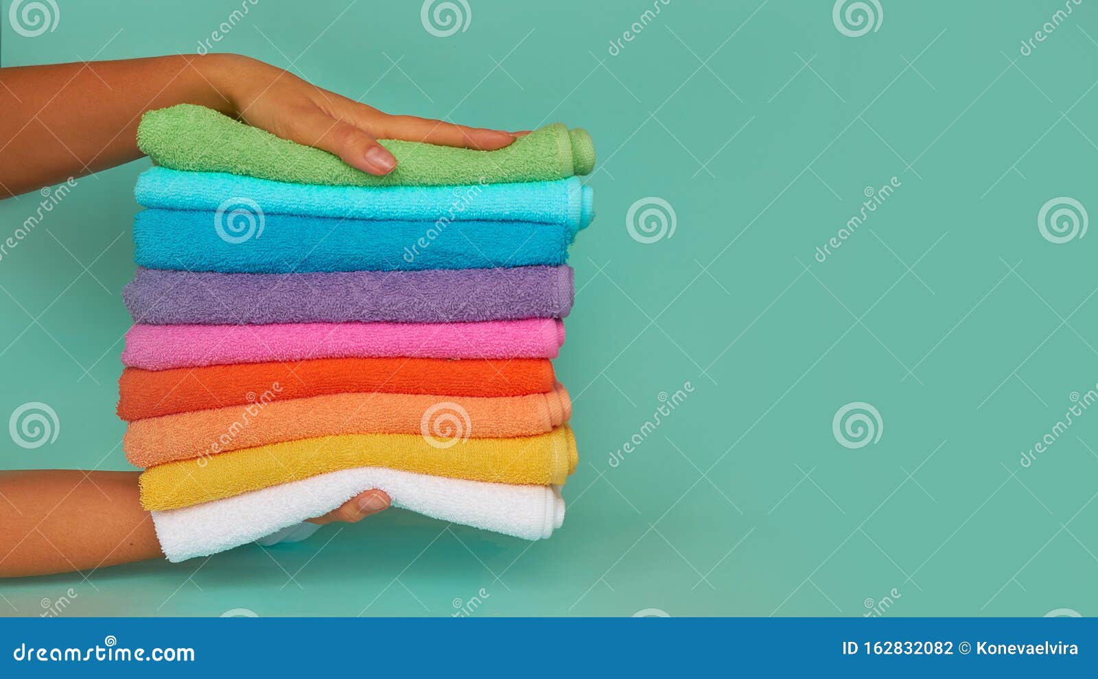 Close-up of Hands Putting Stack of Fresh Bath Towels. Stack of Multi ...
