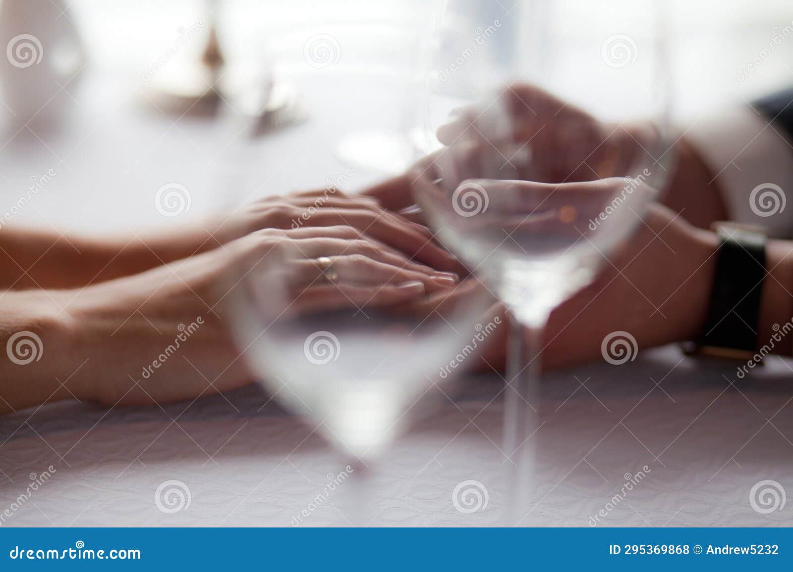 Close-up of Hands Resting on a Table with Wine Glasses, Captured in ...