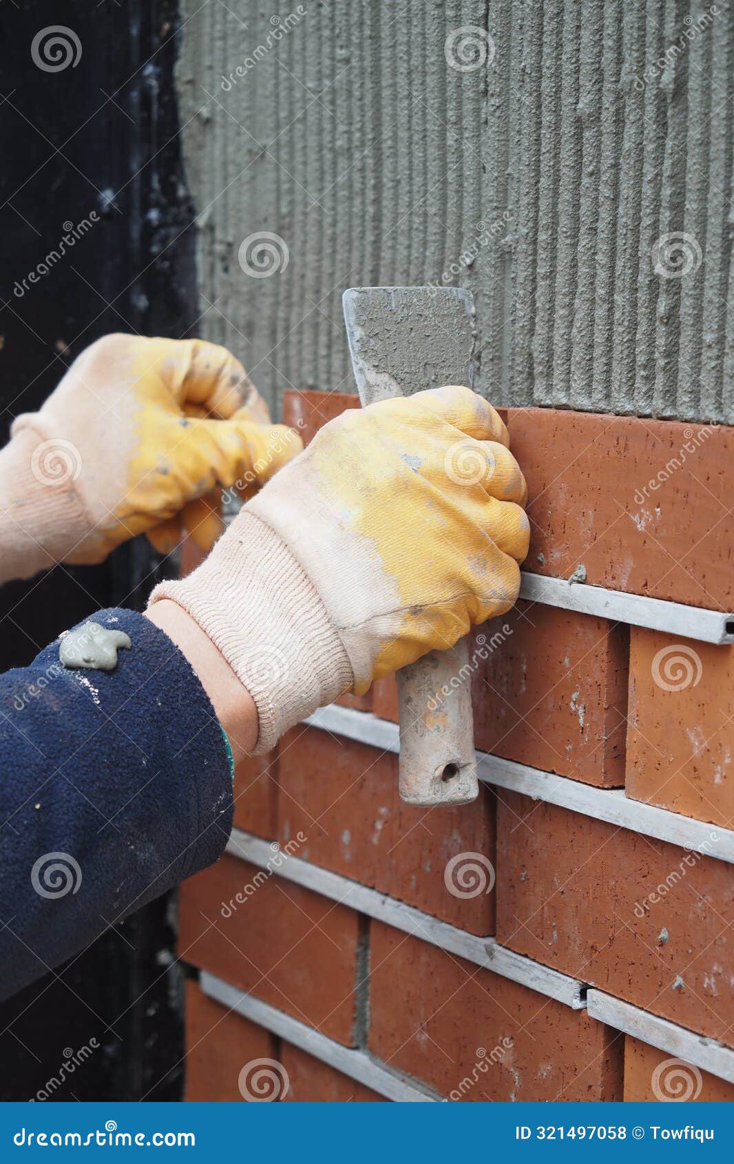 A Bricklayer is Seen Applying Mortar on a Wall As Part of the Building ...