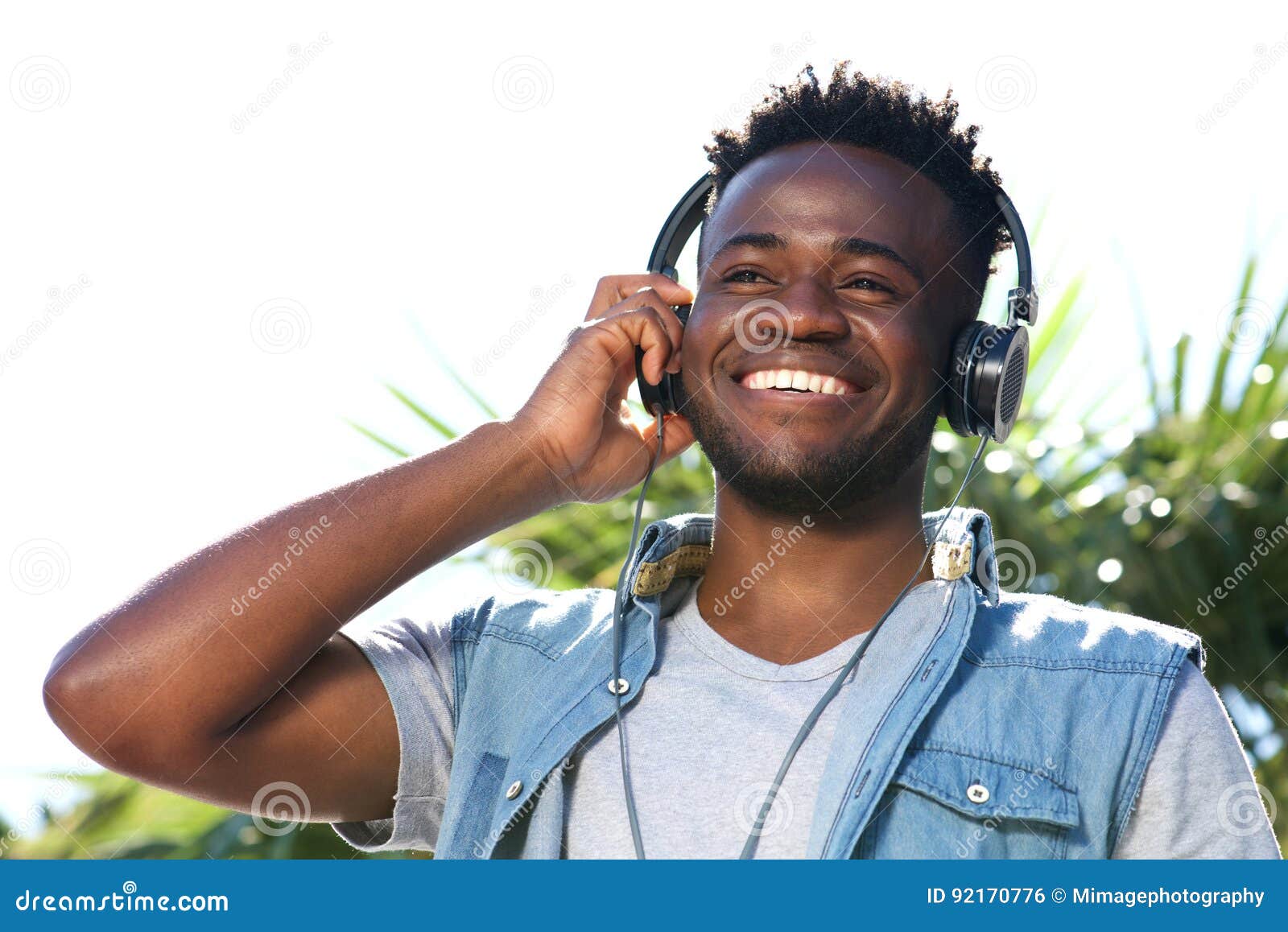 Close Up Happy Young Black Man Listening To Music With Headphones Stock
