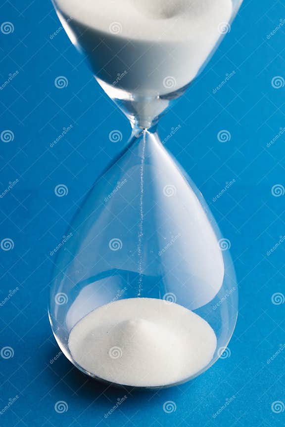 Close Up Of Hourglass With White Sand And Copy Space On Blue Background
