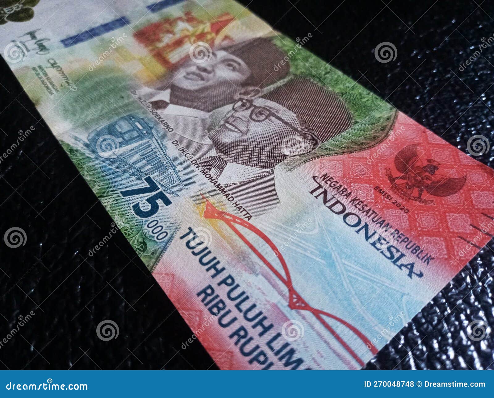 Close-up of an Indonesian Currency, 75.000 Rupiah on a Black Surface ...