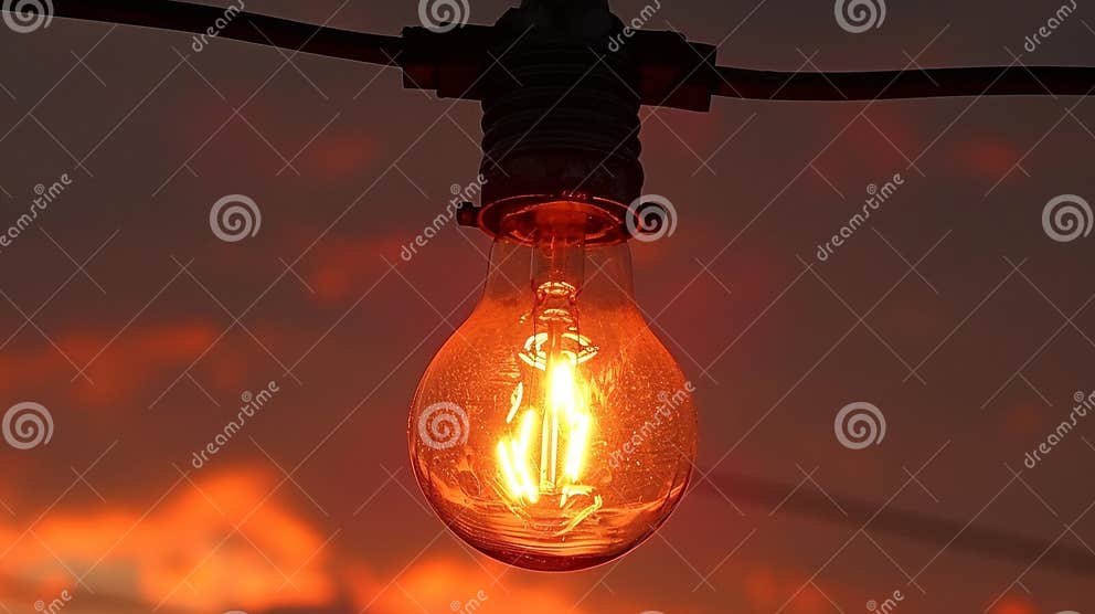 A Close Up of a Light Bulb with the Sun Setting in Front, AI Stock ...