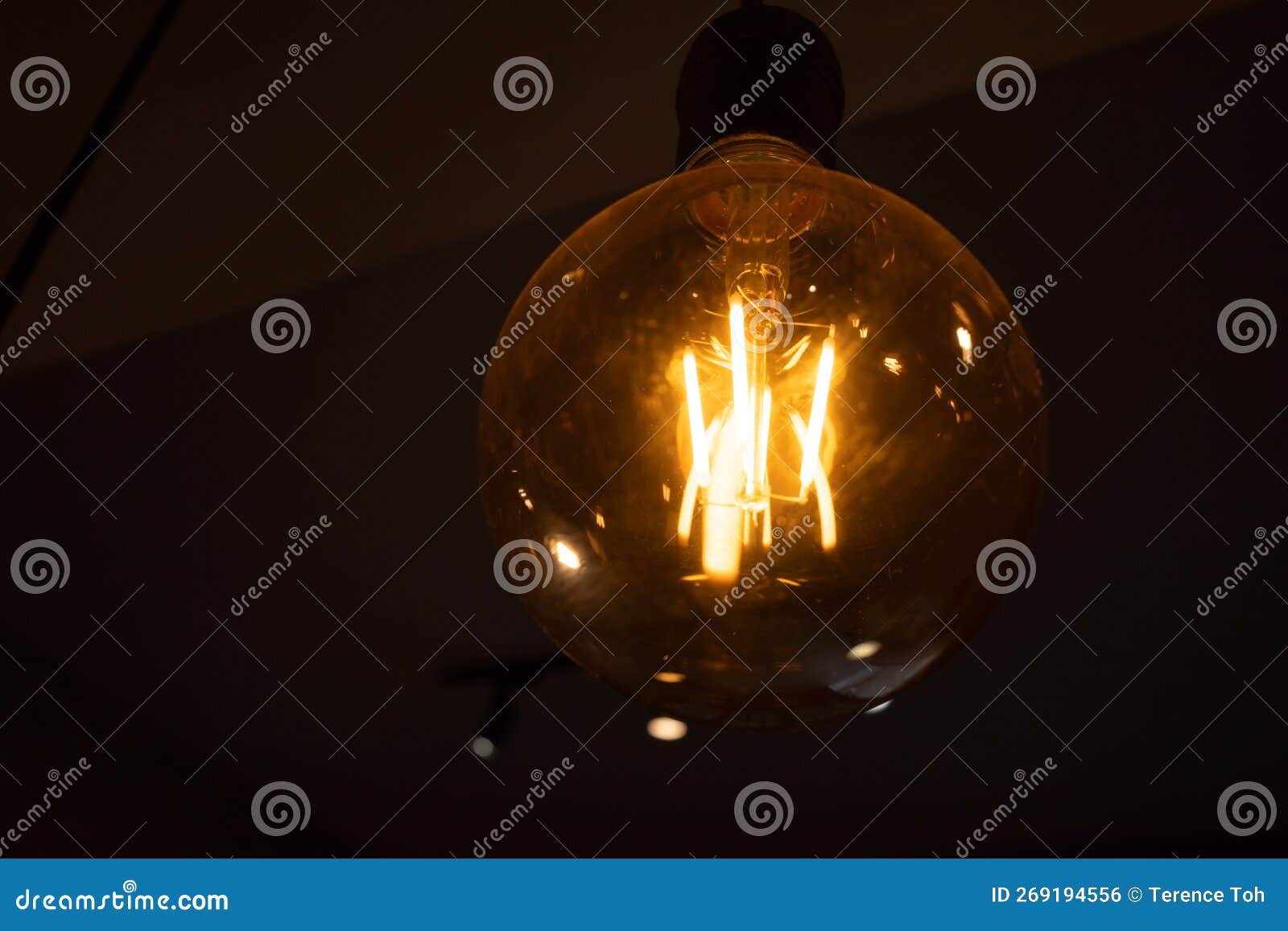 Close Up of a Lightbulb Hanging from a Ceiling Inside a Dark Room Stock ...